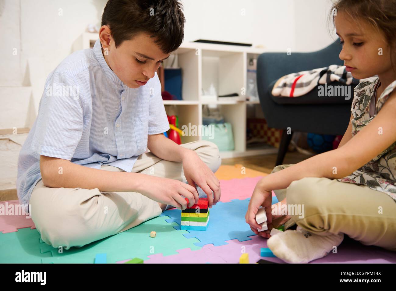 Two children are focused on building structures with colorful blocks ...
