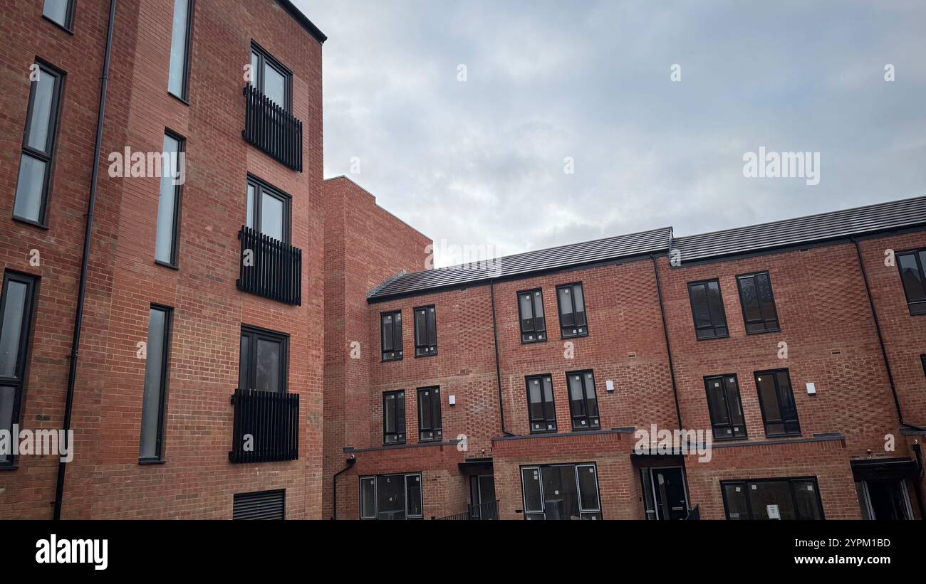 Red brick apartment buildings with black-framed windows and balconies ...