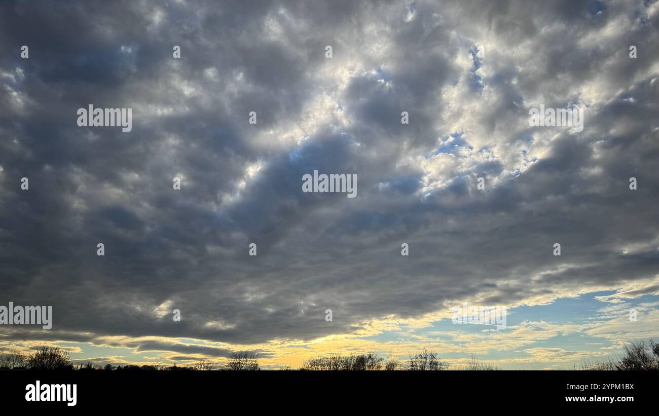 Overcast sky with predominantly dark gray and lighter gray clouds. Patches of blue sky are ...
