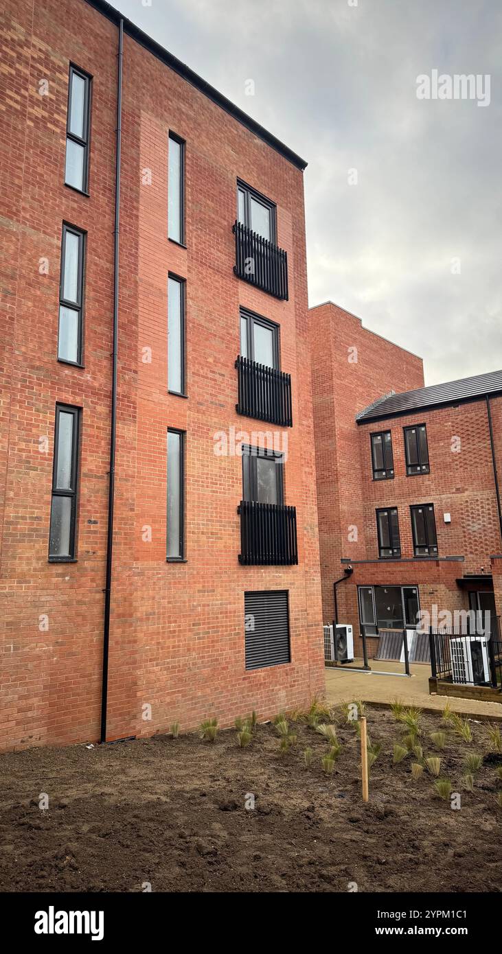 Exterior view of a modern brick apartment building under a cloudy sky ...