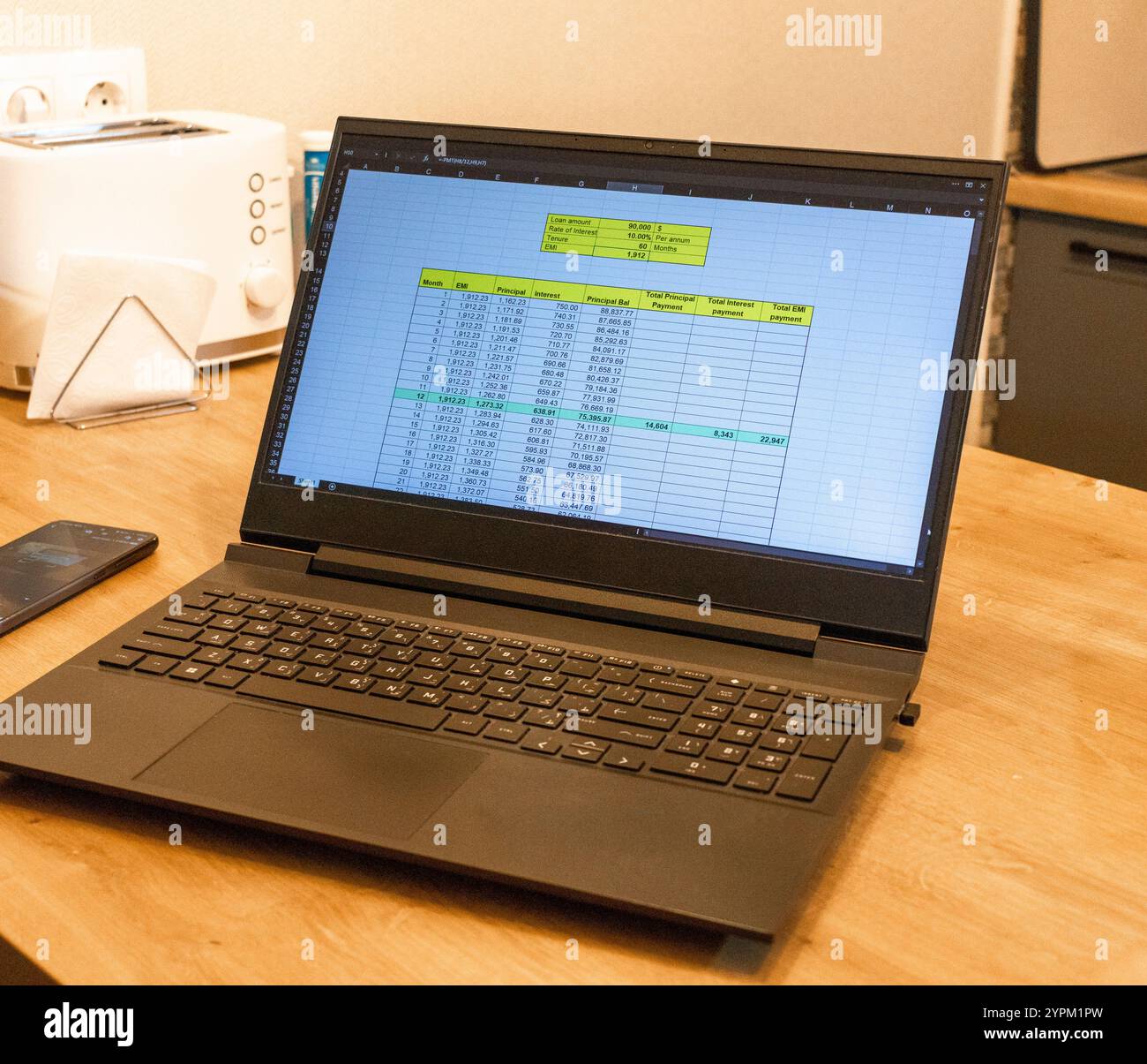 Laptop on the kitchen counter top with an excel sheet on computer ...