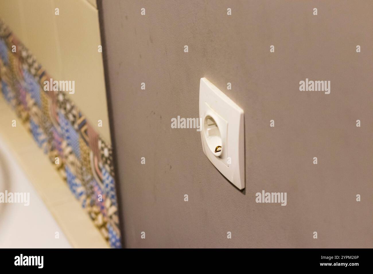 Shot of the decorative tiles and electrical socket in the bathroom ...