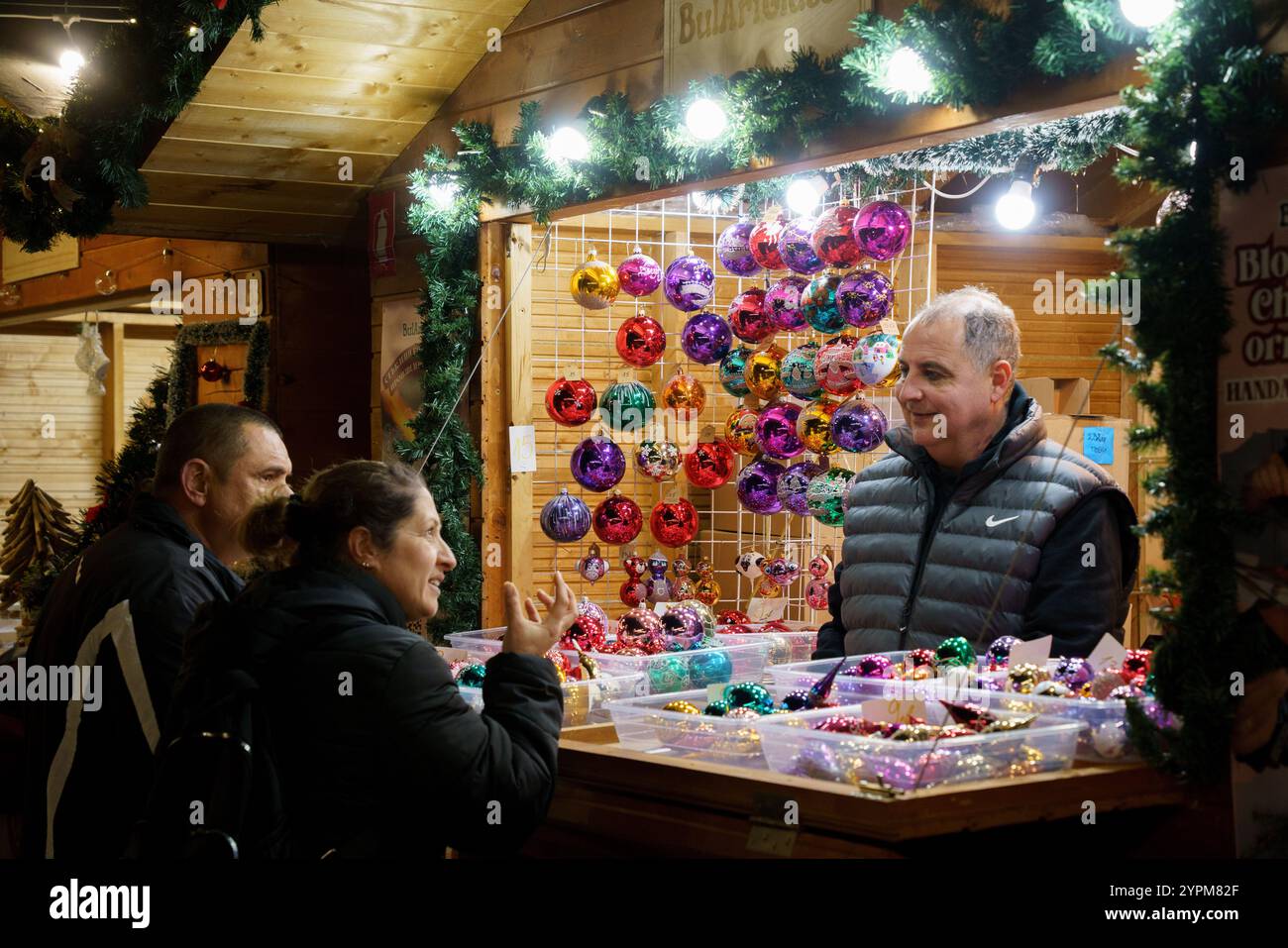 Sofia, Bulgaria- 27-11-2024: A vendor at a kiosk selling Christmas tree ...