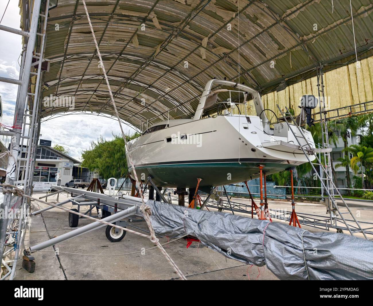 A boat is carefully lifted under a covered structure Stock Photo - Alamy