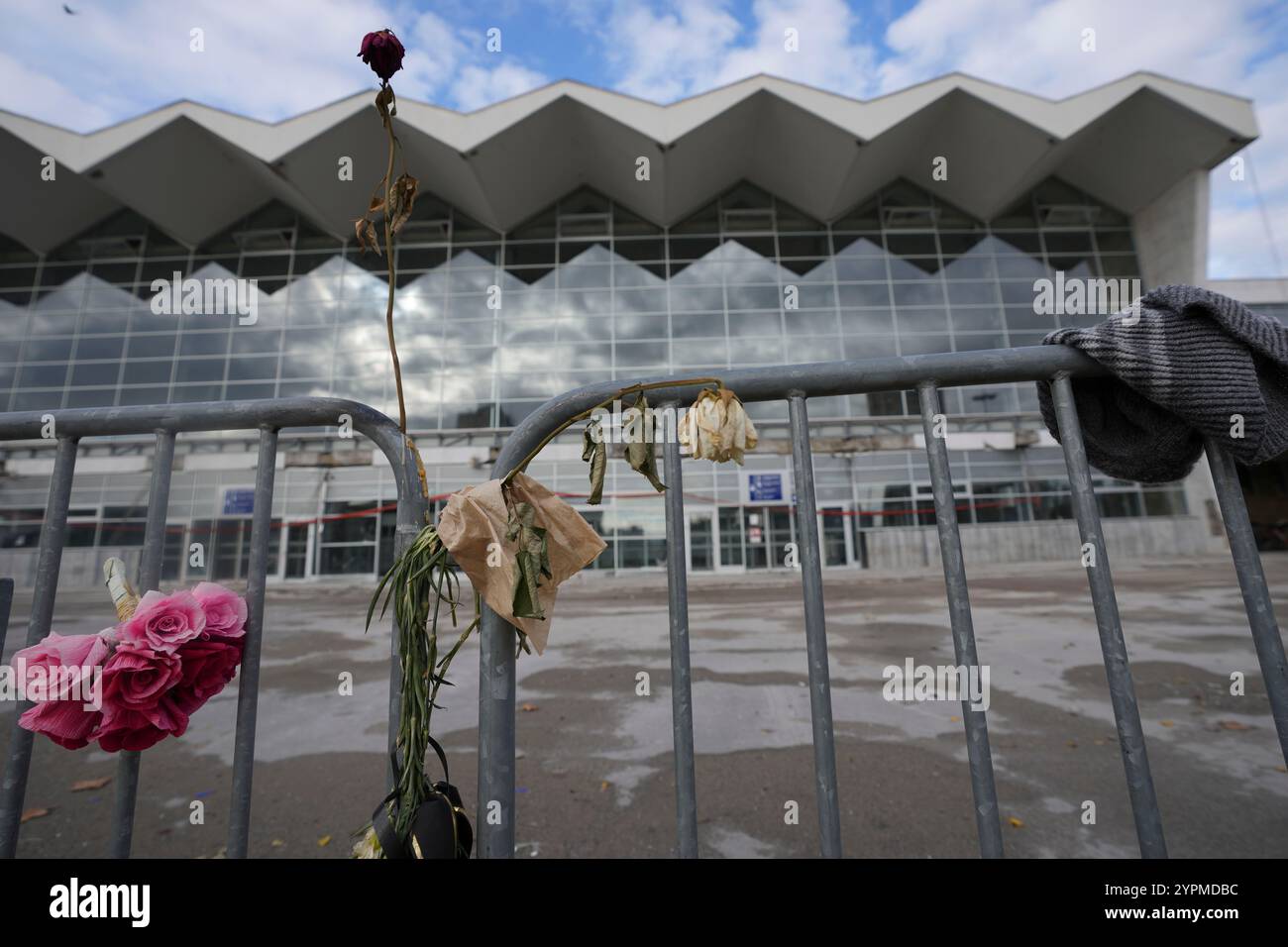 Flowers placed in front of a train station where an outdoor roof ...