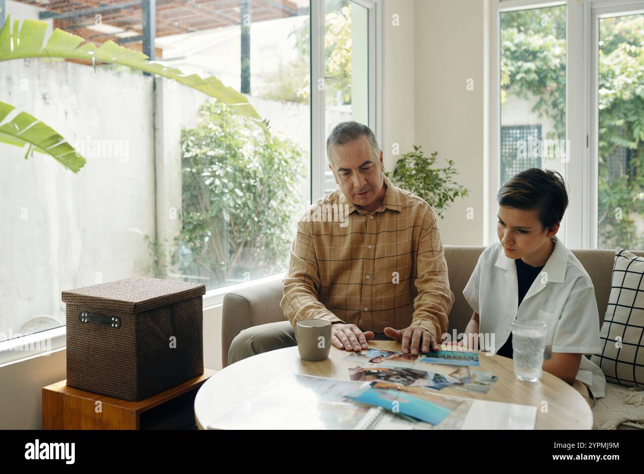 Granddad Showing Family Photos To Grandchild Stock Photo - Alamy