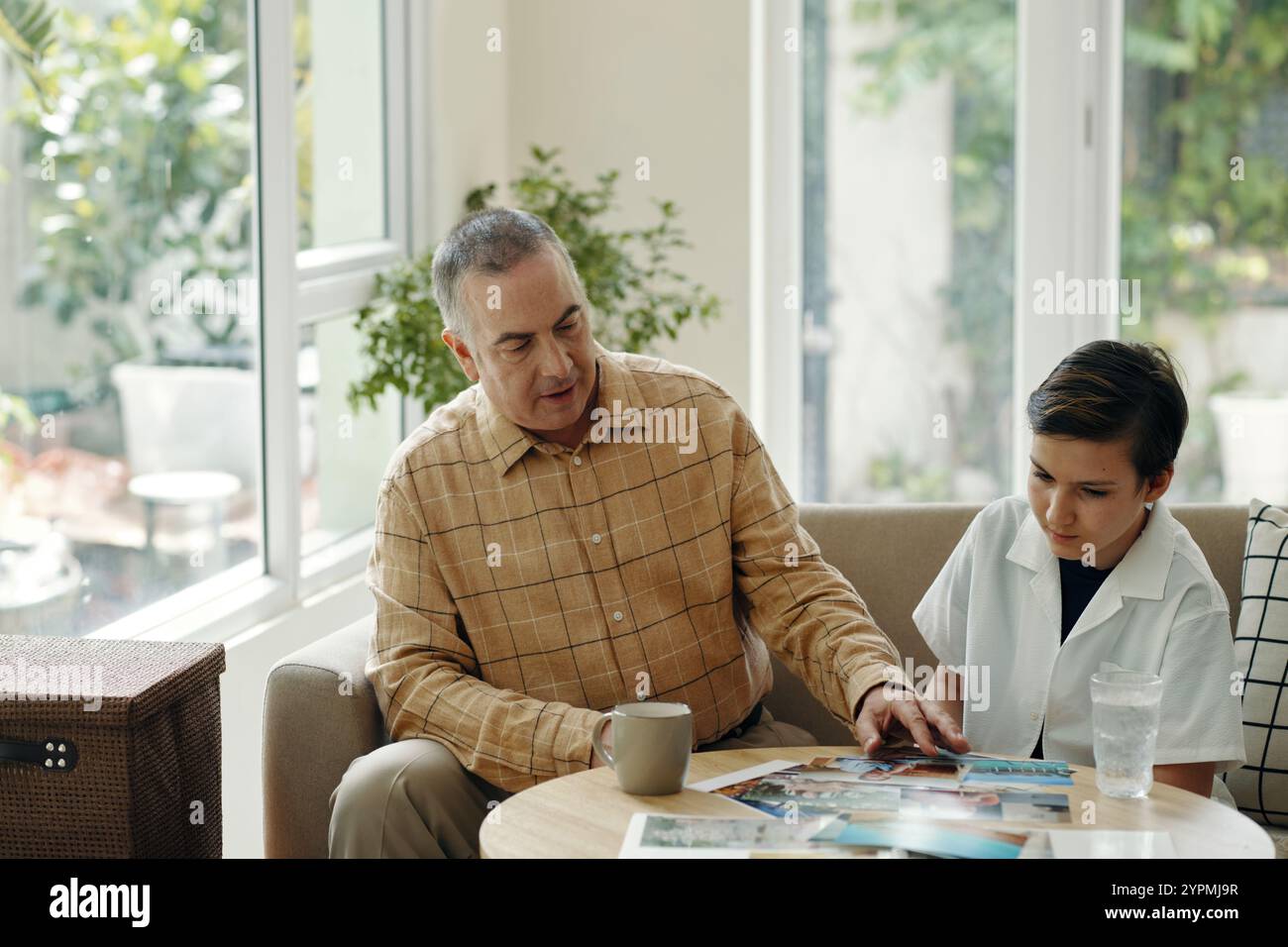 Grandfather Telling Story About Family To Grandson Stock Photo - Alamy