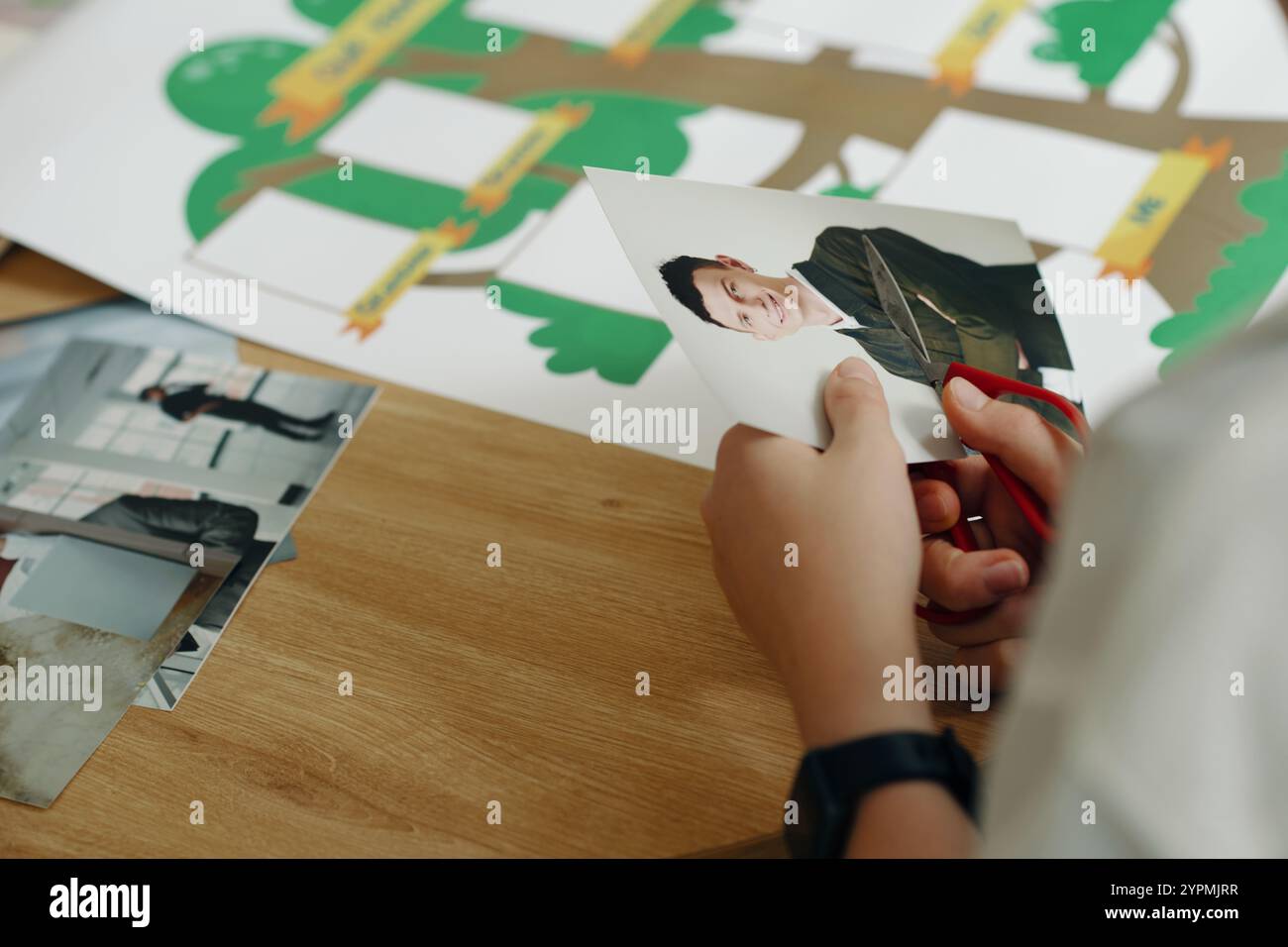 Close-up of boy sitting at table and making family tree from family ...
