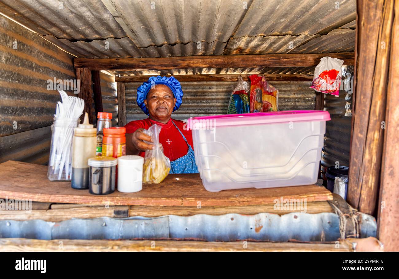 tuck shop , african woman in a shack selling chips, French fries ...
