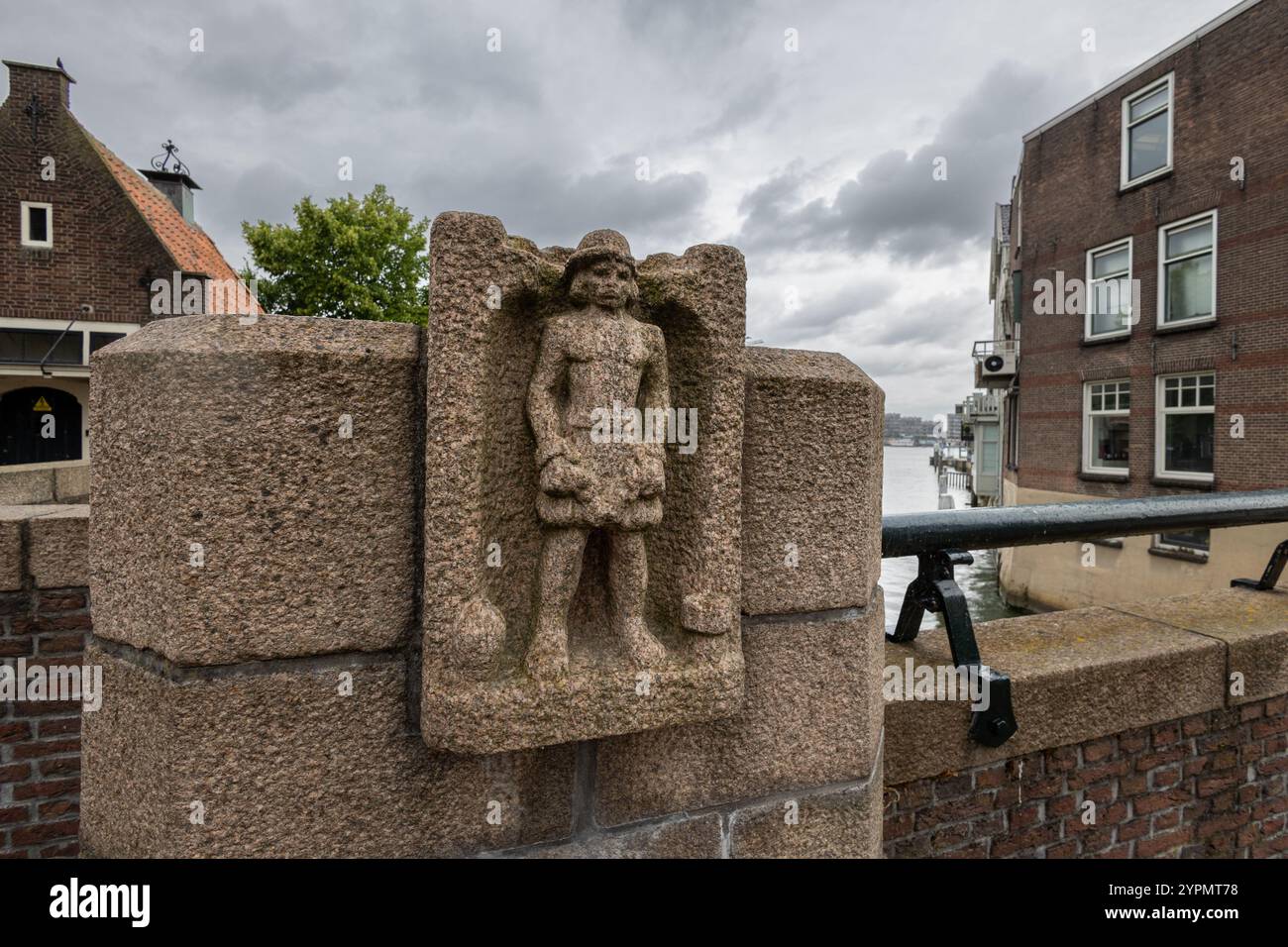 A stone carving of a historic figure set in a brick bridge railing ...