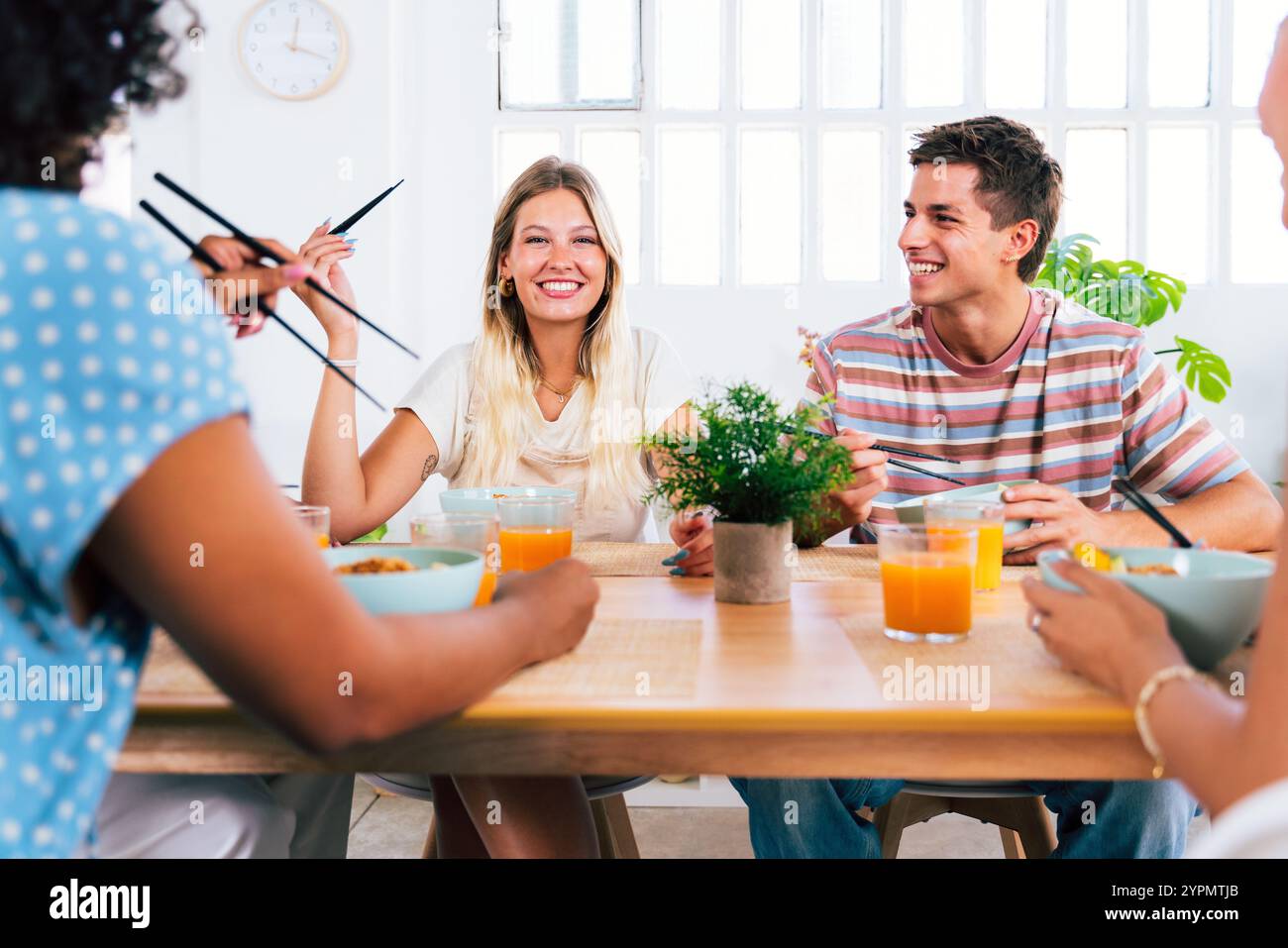 Multiethnic group of young friends meeting at home and eating poke ...