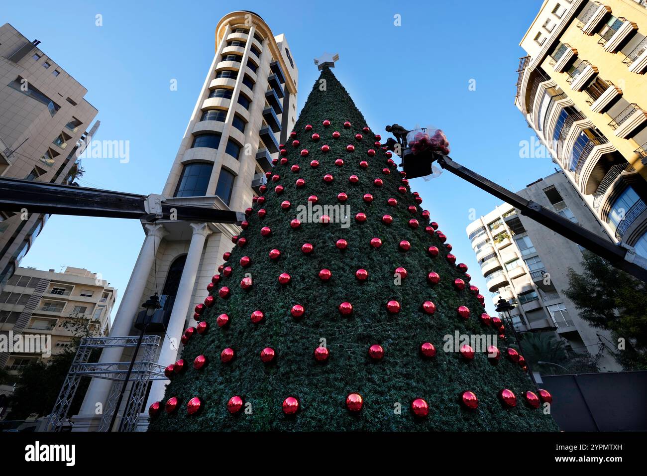 Workers stands on a crane decorating a giant Christmas tree in the ...