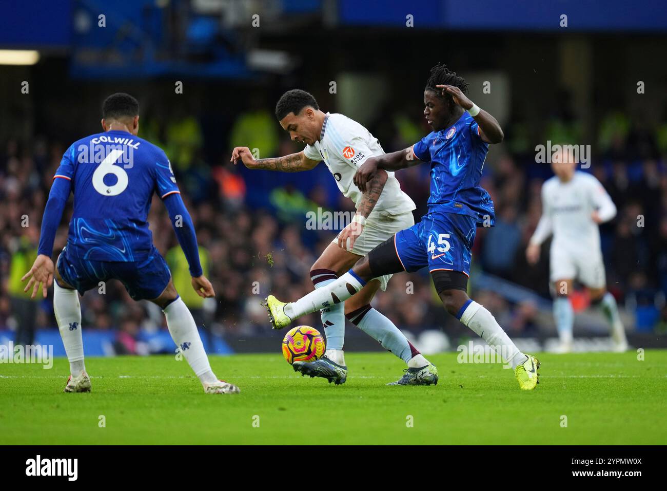Aston Villa's Morgan Rogers, centre, challenges for the ball with ...