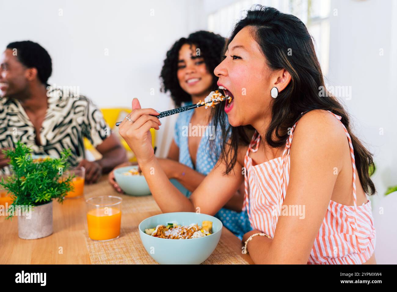 Multiethnic group of young friends meeting at home and eating poke ...
