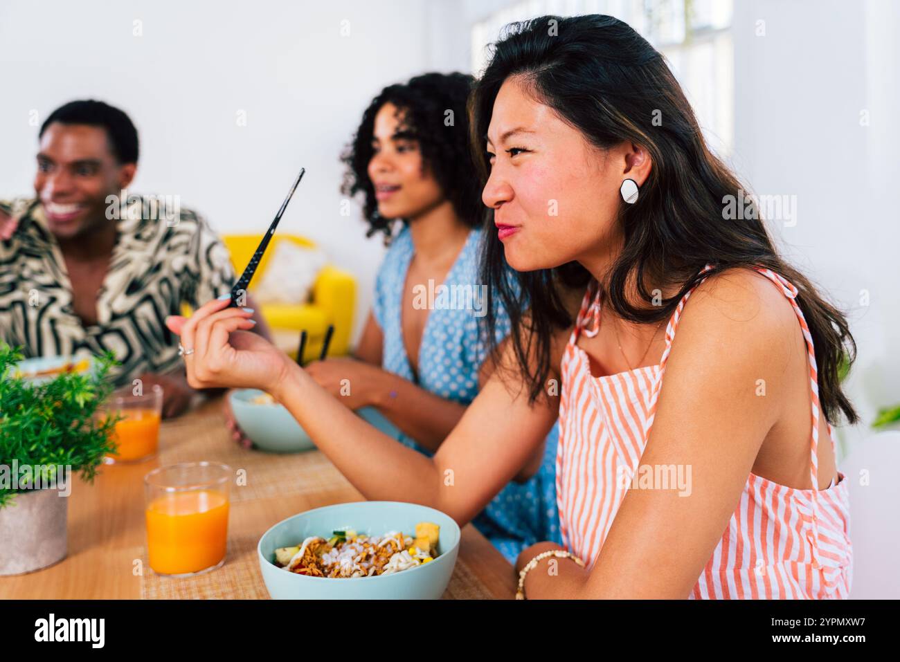 Multiethnic group of young friends meeting at home and eating poke ...