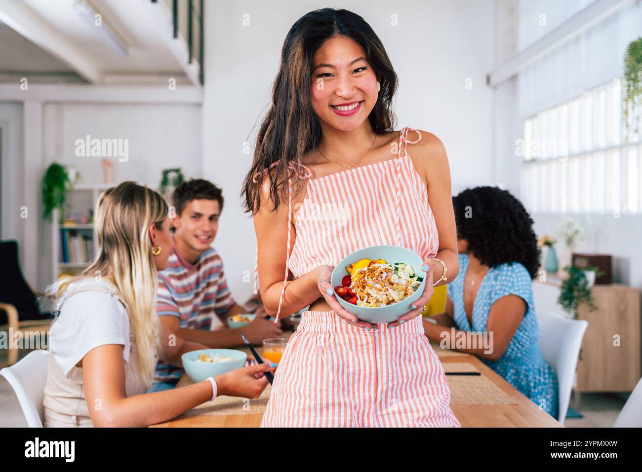 Multiethnic group of young friends meeting at home and eating poke ...