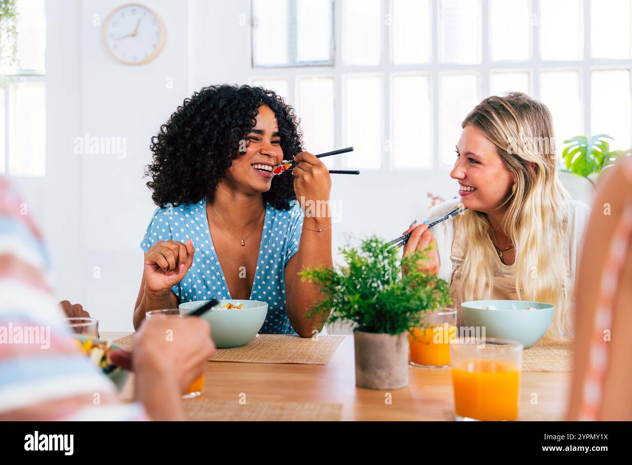 Multiethnic group of young friends meeting at home and eating poke ...