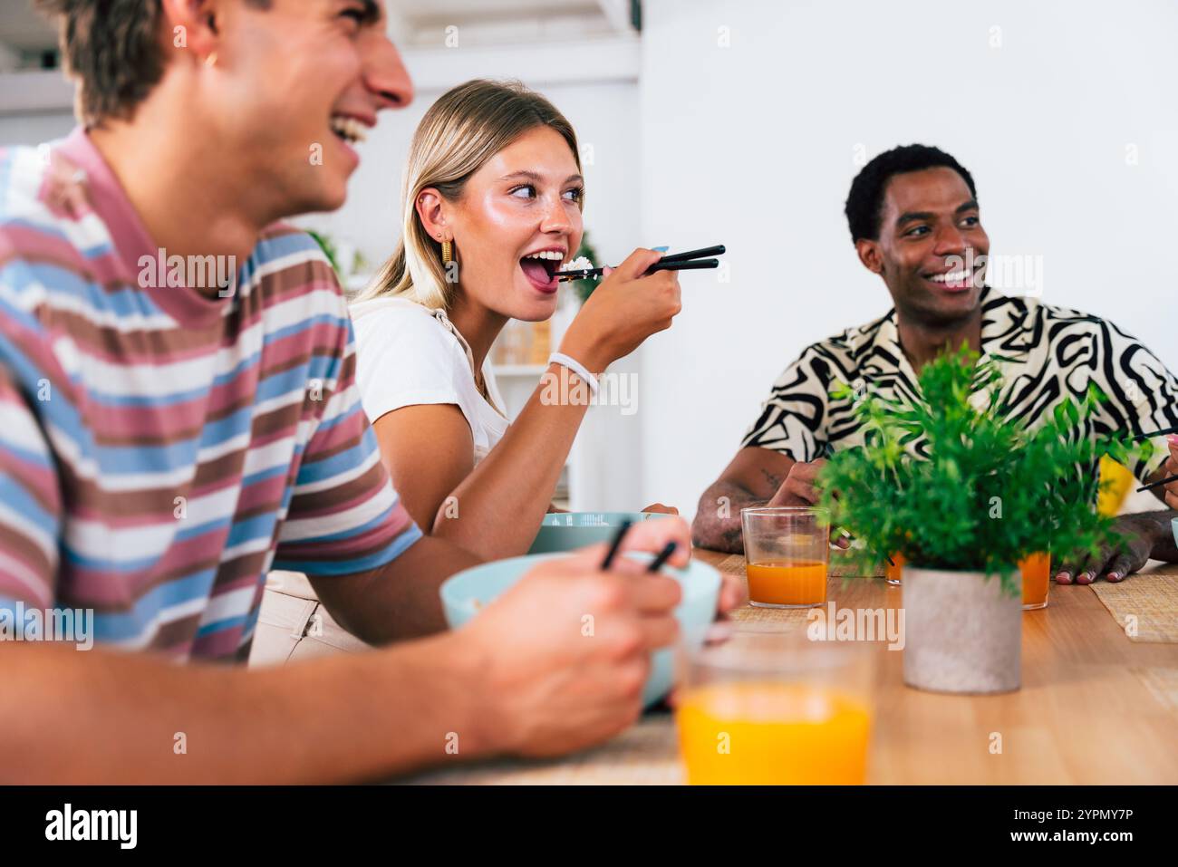 Multiethnic group of young friends meeting at home and eating poke ...