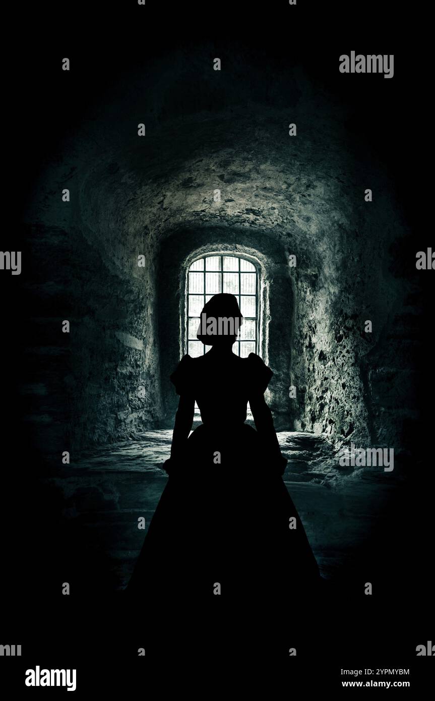 mysterious woman standing in a medieval dungeon or prison with a small ...