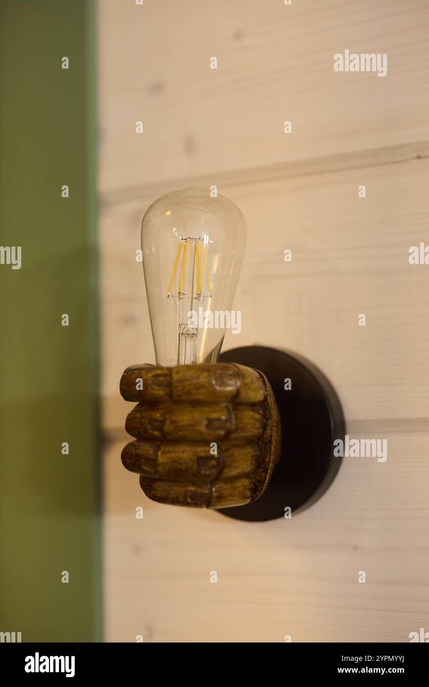 This handshaped light fixture uses a classic Edison bulb, adding ...