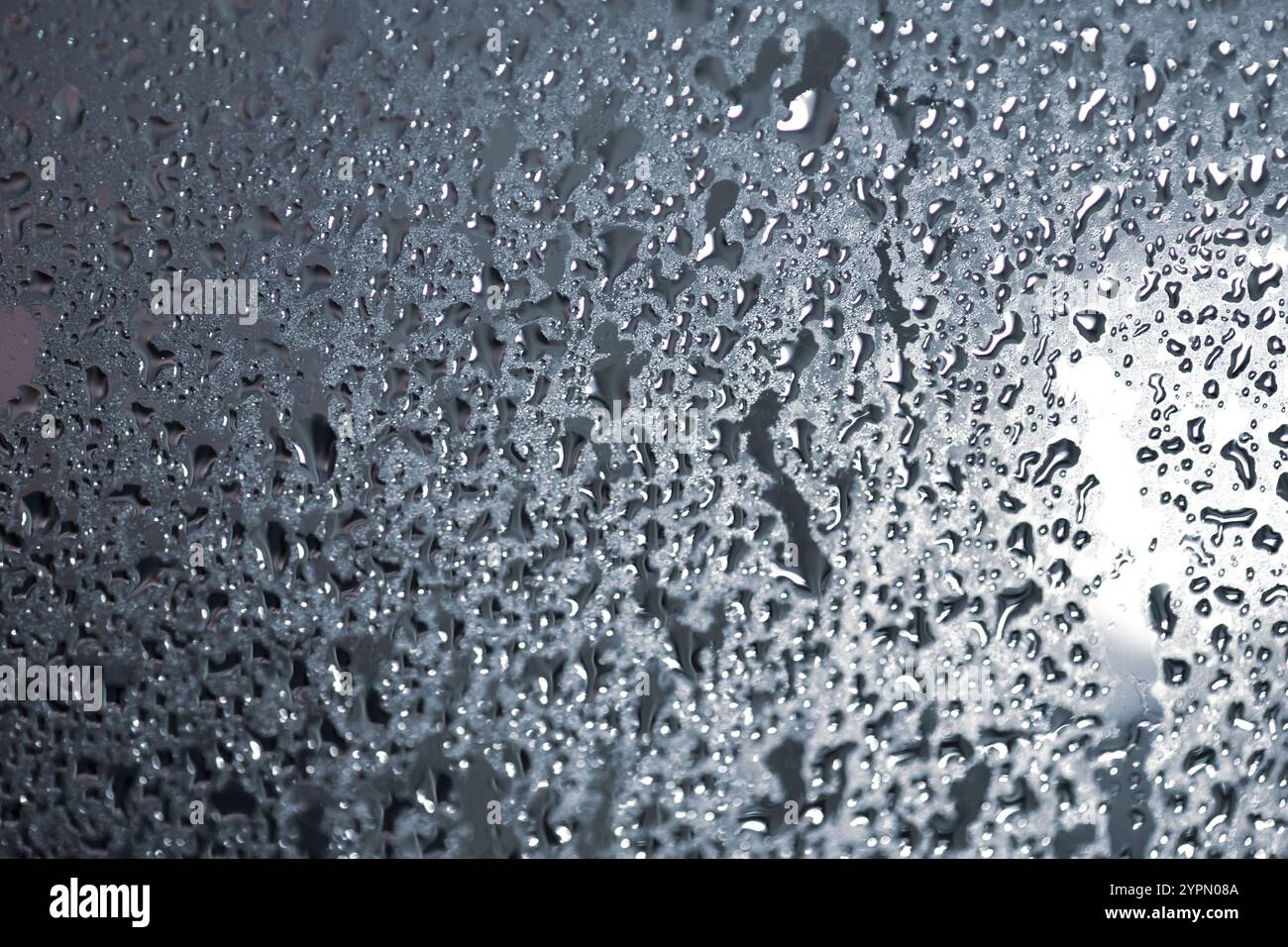 A window with raindrops on it. The drops are small and scattered. The ...
