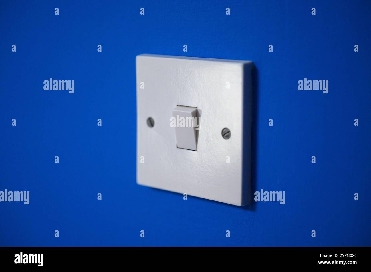 White light switch on a vibrant blue wall Stock Photo - Alamy