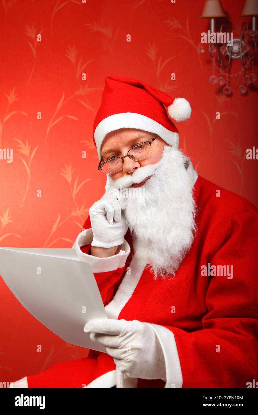 Santa Claus reads the letter carefully Stock Photo - Alamy