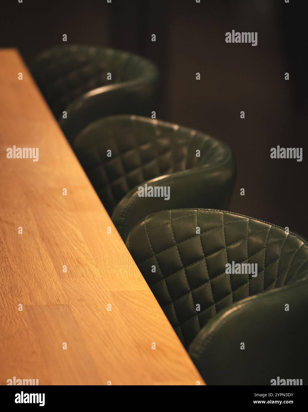 A row of 3 cosy kitchen chairs lined up against a breakfast bar Stock ...