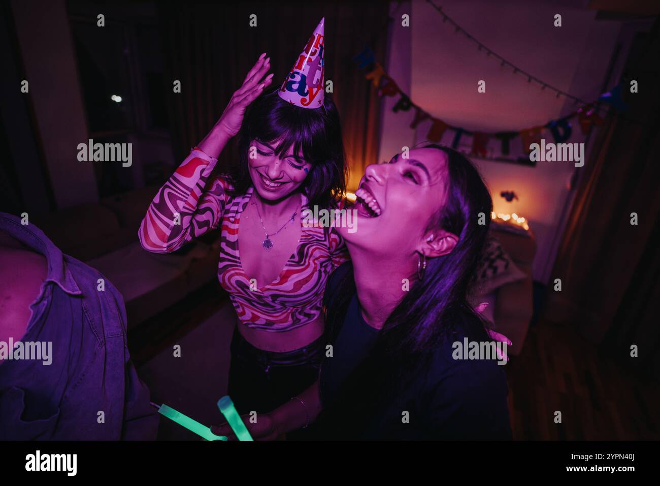 Two friends enjoy a vibrant birthday party, laughing joyfully while ...