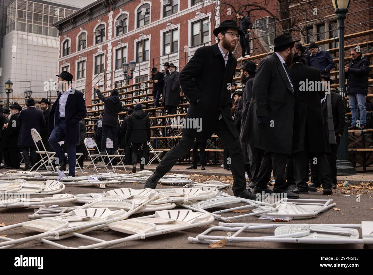 A Hasidic Jewish rabbi jumps over chairs as he leaves the annual group ...