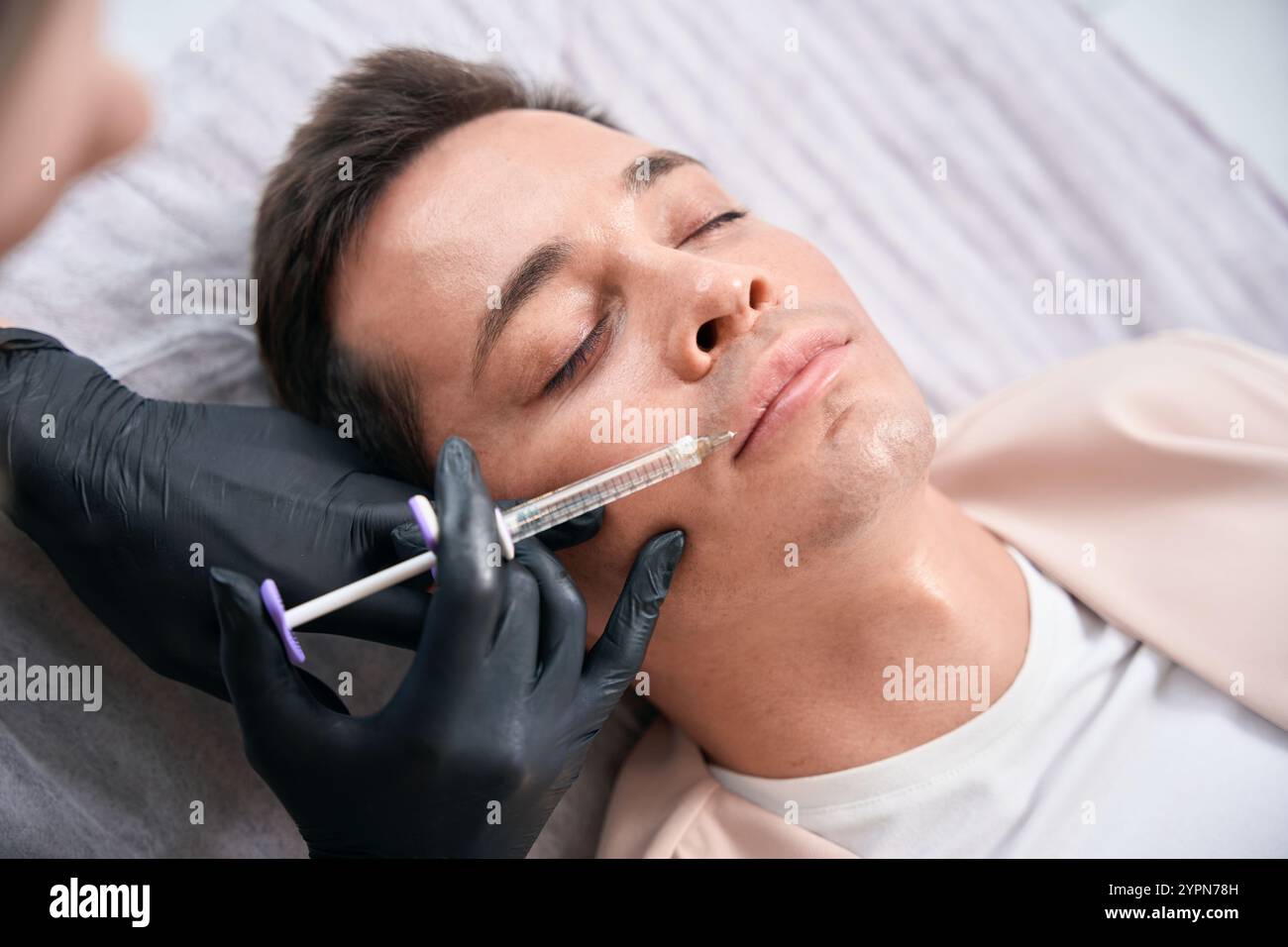 Top view woman cosmetologist doing injections of filler into male ...