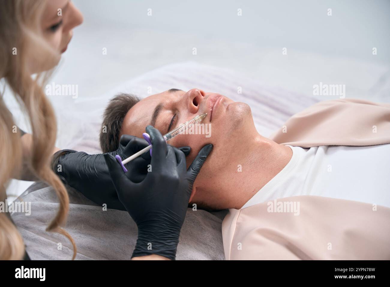 Skilled woman beautician holding special syringe, making filler ...