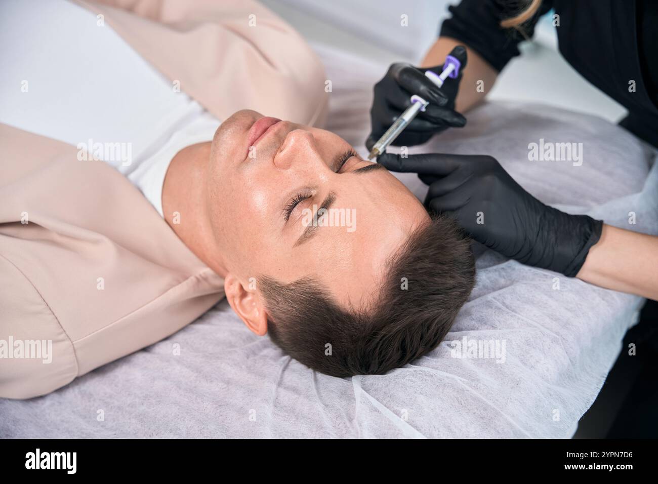 Man looking relaxed attending filler injections procedure Stock Photo ...