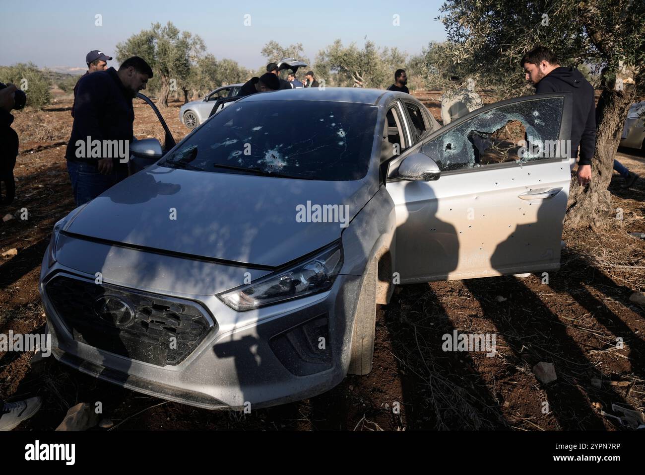 People inspect a car riddled with bullet holes after an Israeli army ...