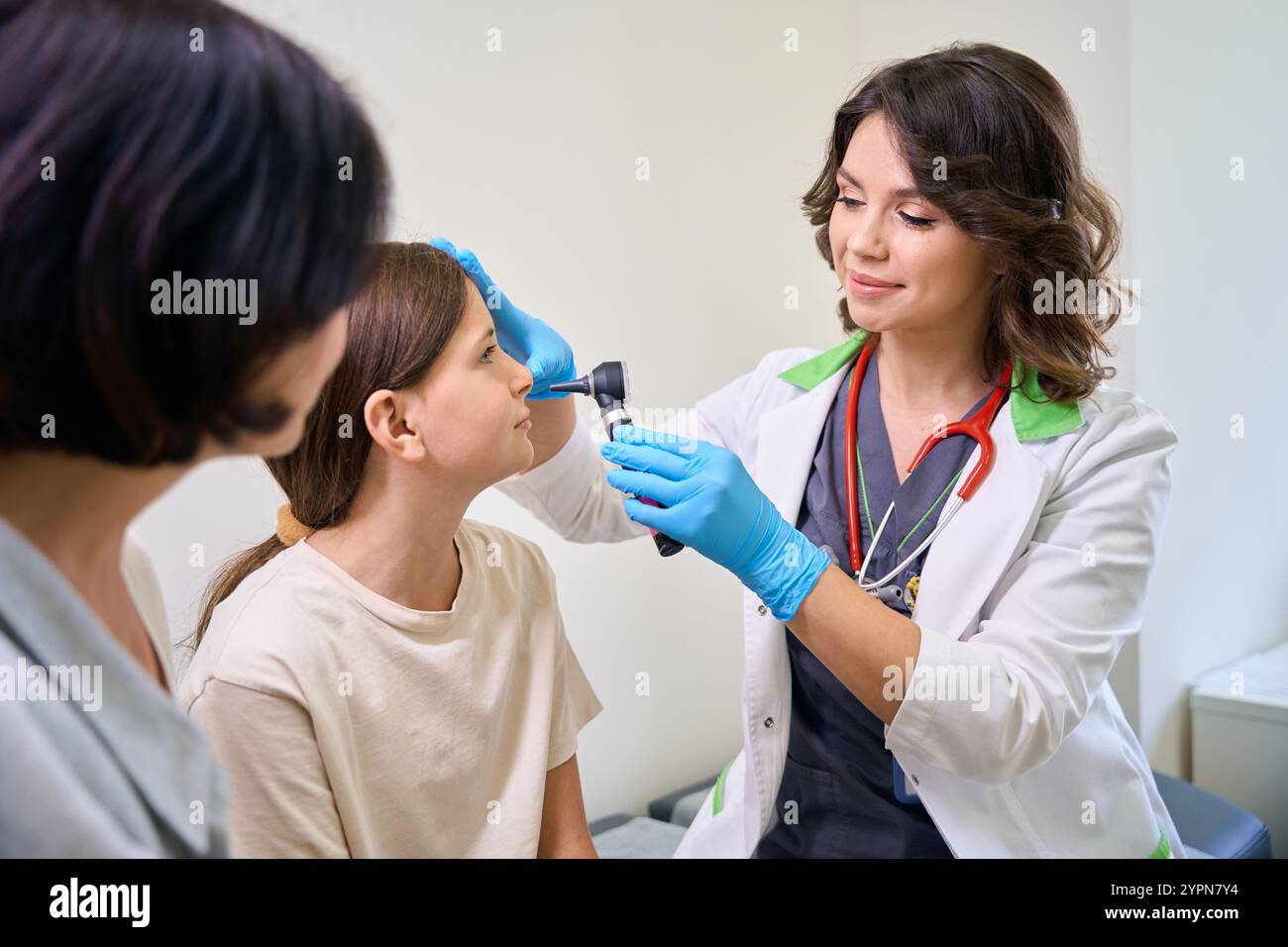 Young doctor examines the nose of a teenage patient, a specialist uses ...