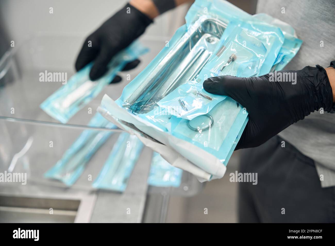 Medical technician putting sterile tools in heat-sealing packages into ...