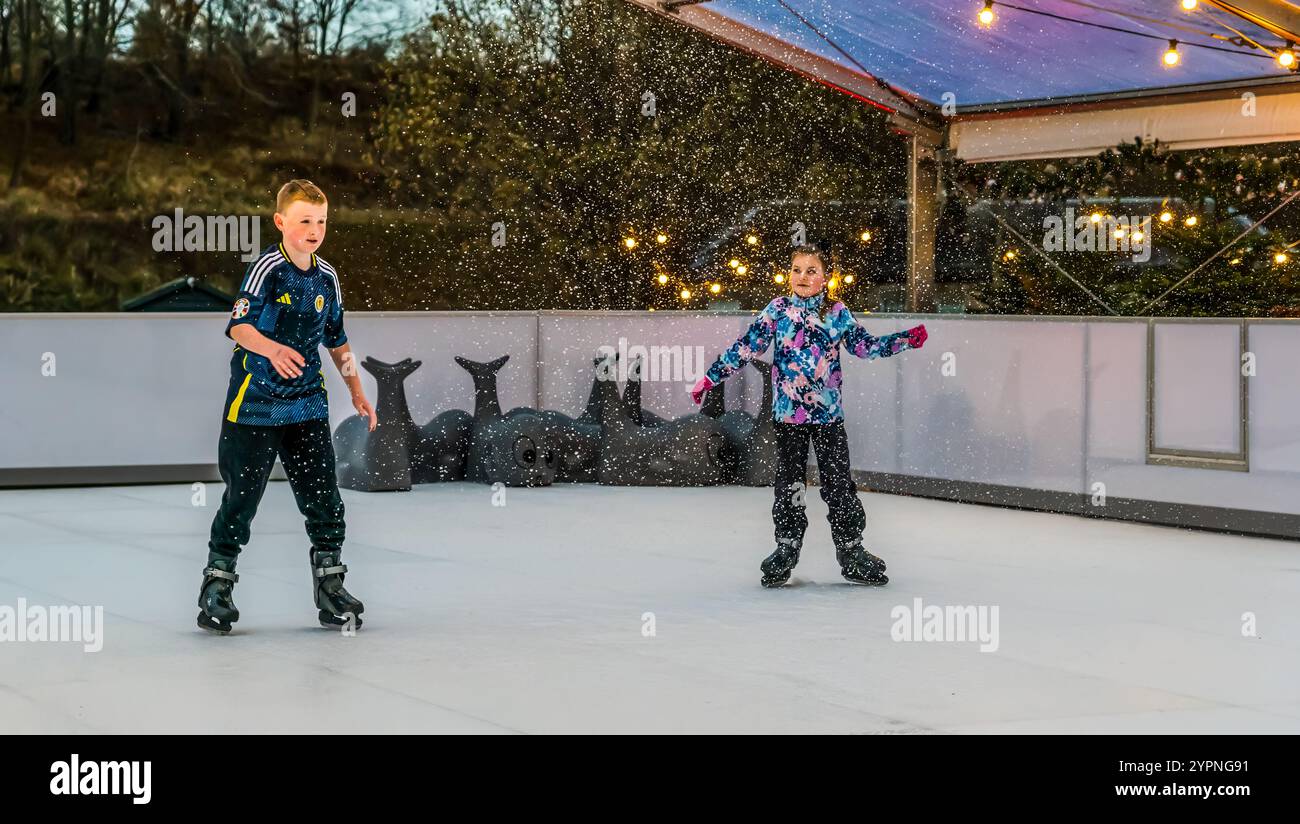 Children enjoying fun on a sustainable eco-friendly ice skating rink ...