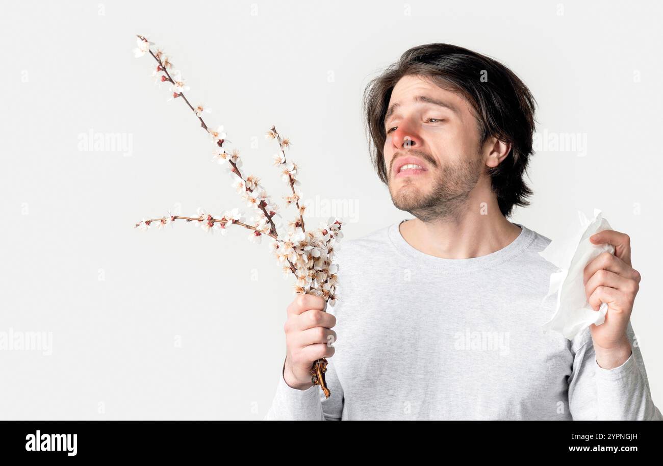 Allergy and bad feeling concept. Man holds flowers Stock Photo - Alamy