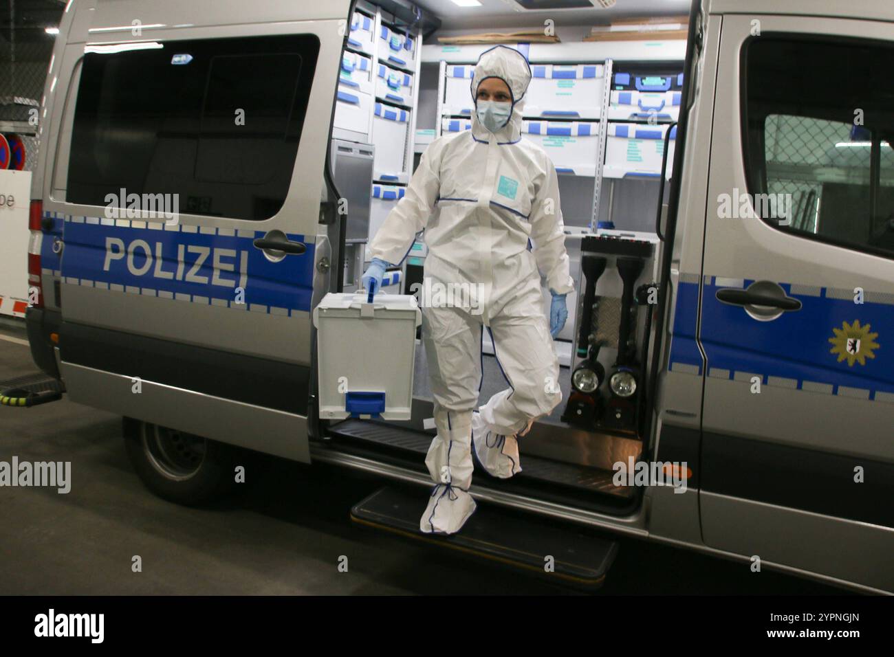 spurensicherin im weißen overall mit koffer vor dem spurensicherungsbus ...