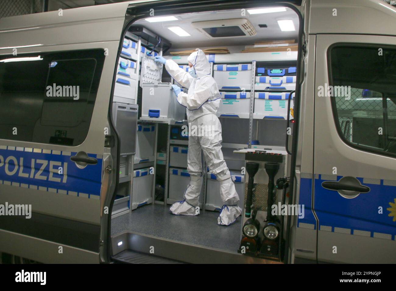 spurensicherin im weißen overall mit koffer vor dem spurensicherungsbus ...