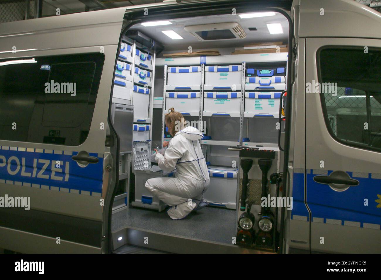 spurensicherin im weißen overall mit koffer vor dem spurensicherungsbus ...