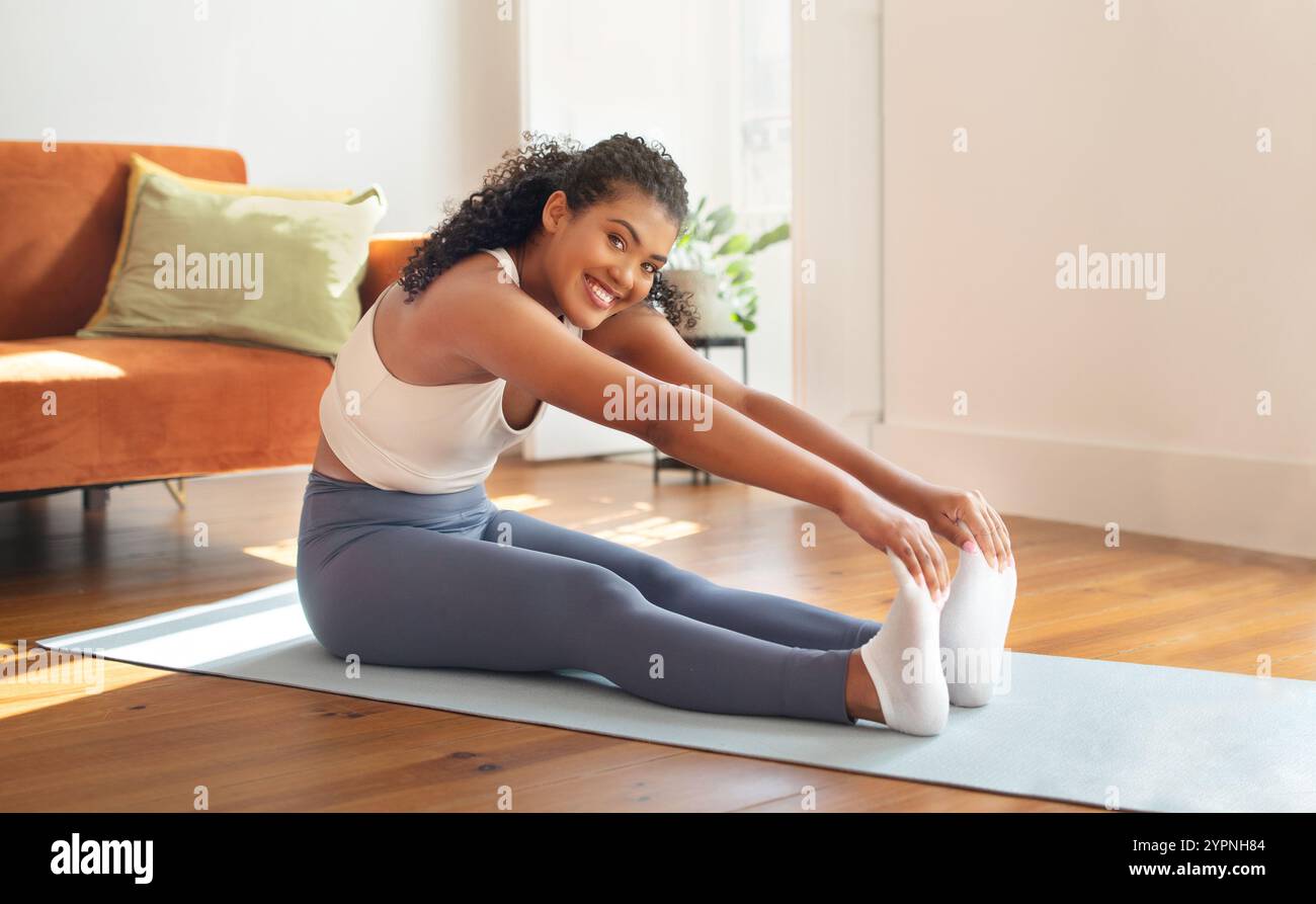 woman exercising doing seated toe touch in living room Stock Photo - Alamy