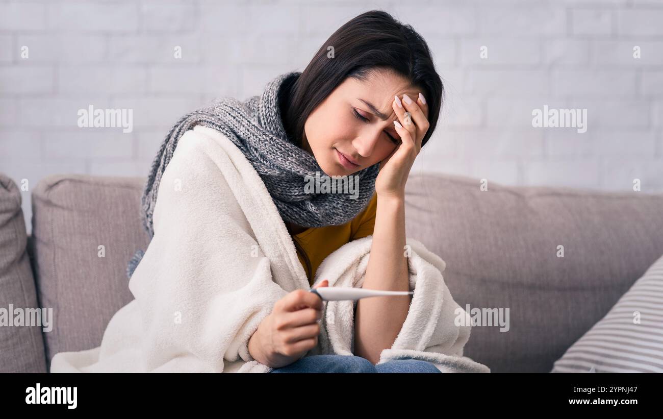 Contagious disease. Young girl having high fever and looking at ...