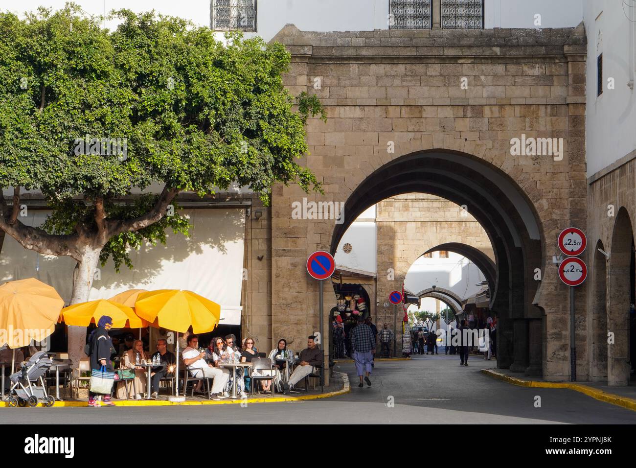 The big Habous Gate with a stone archway and people sitting at an ...
