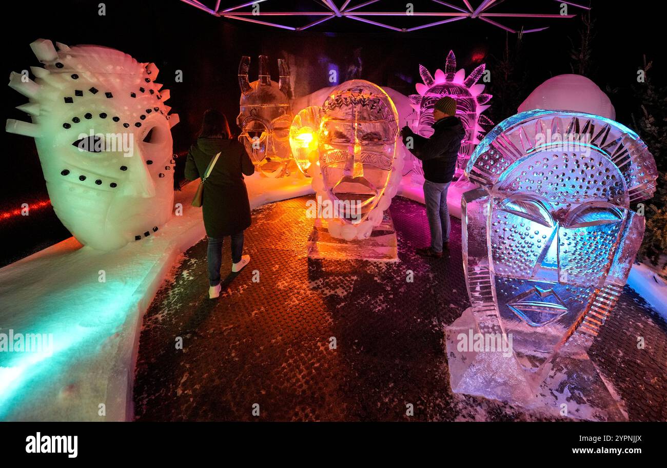 Visitors watch ice-cold artworks at an ice and snow sculpture ...