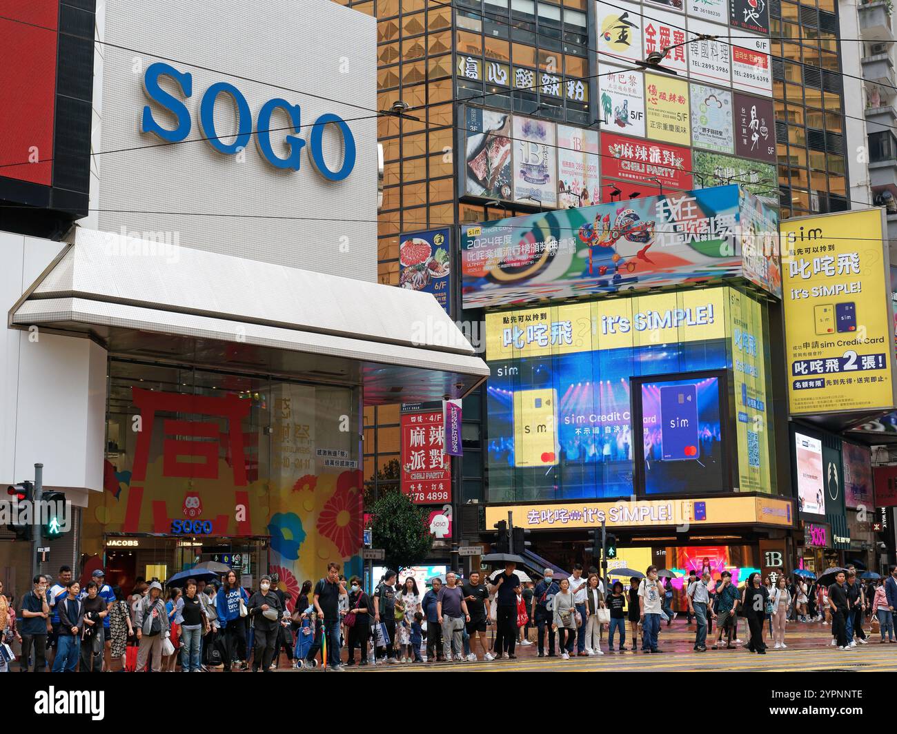 View of pedestrians waiting to cross the busy crossing in front of the popular Sogo store on ...