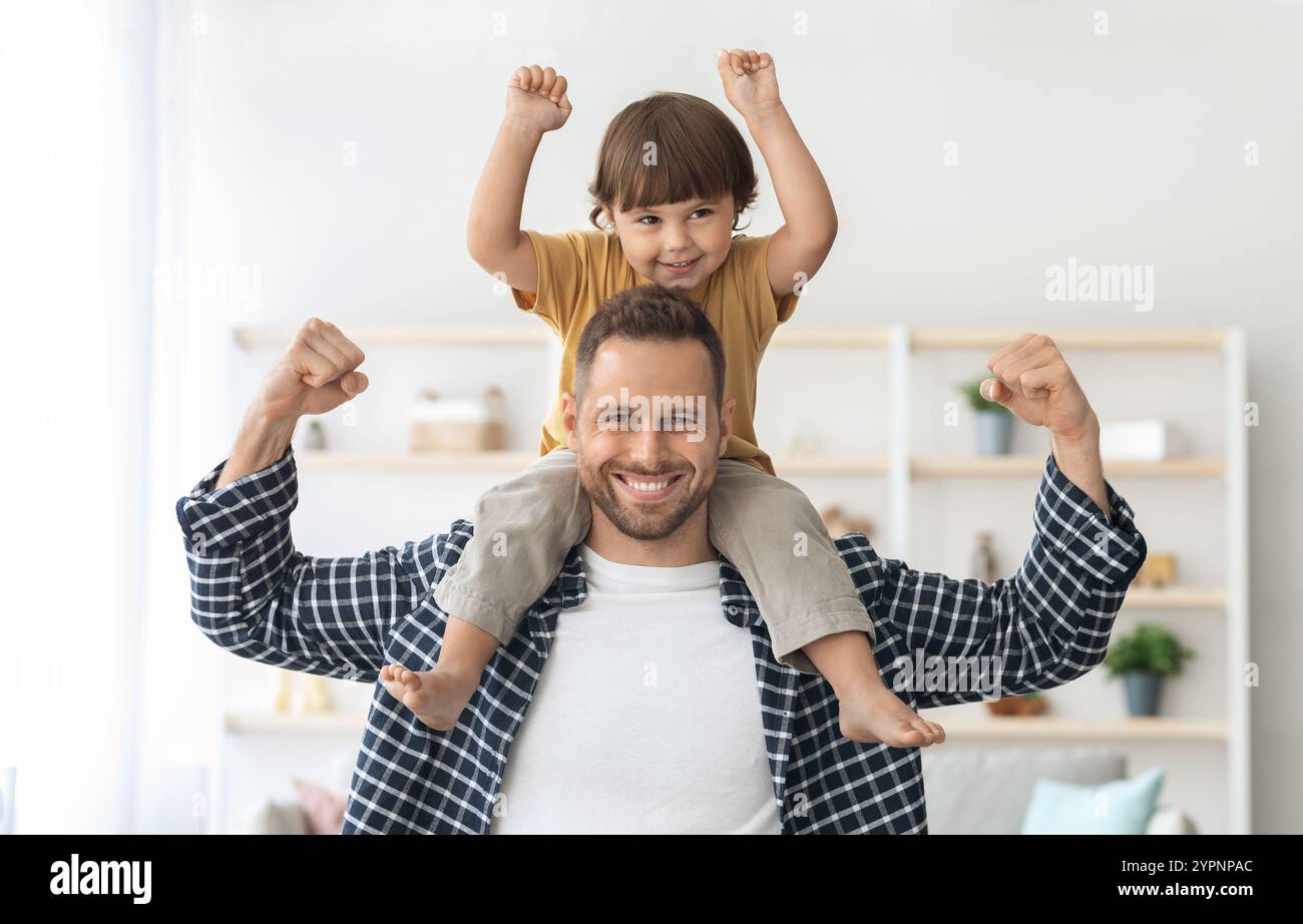 Family power. Strong young man carrying his little son on shoulders ...