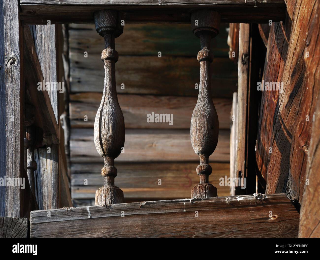 a close-up of intricately carved wooden balusters in a rustic, aged ...