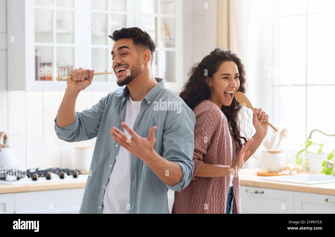 Home Concert. Playful Arab Spouses Having Fun In Kitchen, Singing And ...