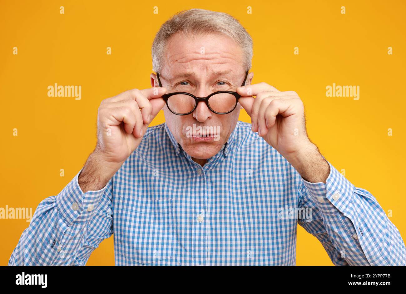 Mature man squinting wearing eyeglasses, looking at camera Stock Photo ...